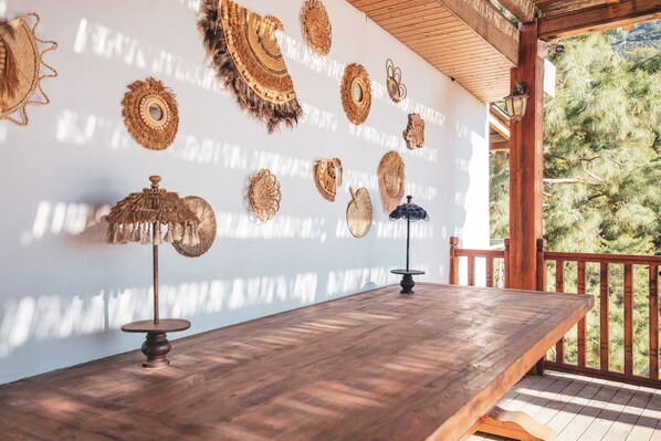 Uma mesa de madeira com guarda-corpo e objetos decorativos presos à parede.