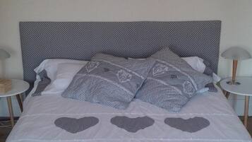 Uma cama com cabeceira, travesseiros e cobertor.