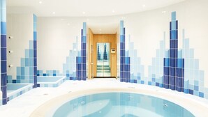 Piscina interna moderna com vista clara para a entrada e uma porta de madeira.