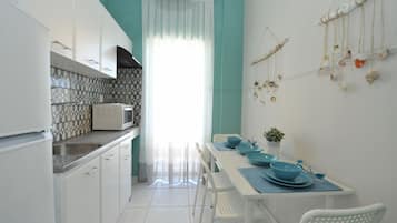 Apartamento, 2 quartos (4 Adults) | Cozinha americana privada | Geladeira, cooktop, chaleira elétrica, cadeirão de bebê