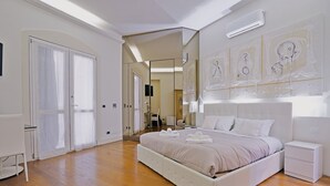 Quarto moderno com uma cama grande, mesa de cabeceira e guarda-roupa.