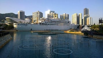 Um cruzeiro atracado em um porto, com um horizonte urbano ao fundo.
