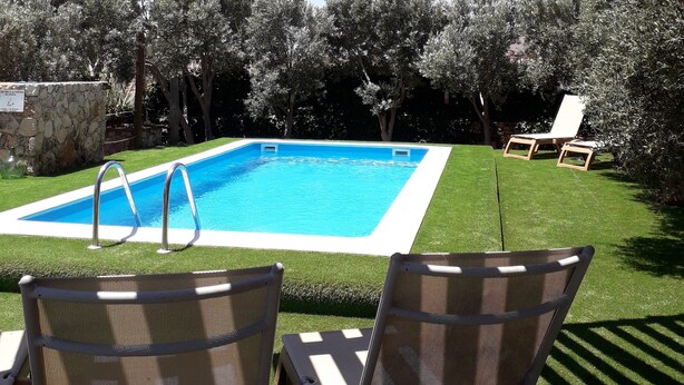 Uma área de piscina com duas espreguiçadeiras e um pergolado.