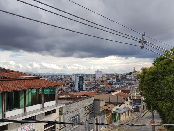 Paisagem urbana com mistura de edifícios residenciais e comerciais, incluindo um arranha-céu imponente.