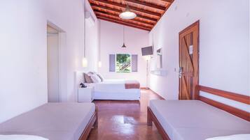 Quarto com duas camas, teto de madeira, janela com persianas e porta.