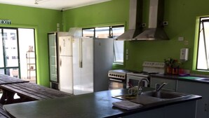 Uma cozinha compacta com ilha central, geladeira, fogão e pia.