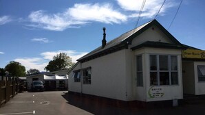 A small building with a sign that reads "Peace Haven B" and "OFFICE". There is a parking lot in front of the building.