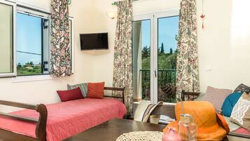 Apartamento standard, 1 quarto, vista para o mar | Área de estar | TV de tela plana 32 polegadas com canais digitais