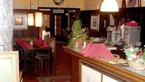Uma sala de jantar com mesa e cadeiras, uma cozinha com eletrodomésticos e um pinheiro de Natal.