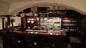Uma área de bar com balcão alto, banquetas e um letreiro que diz "Radeberger Pilsner".