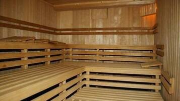 Uma sauna com bancos de madeira e teto inclinado.