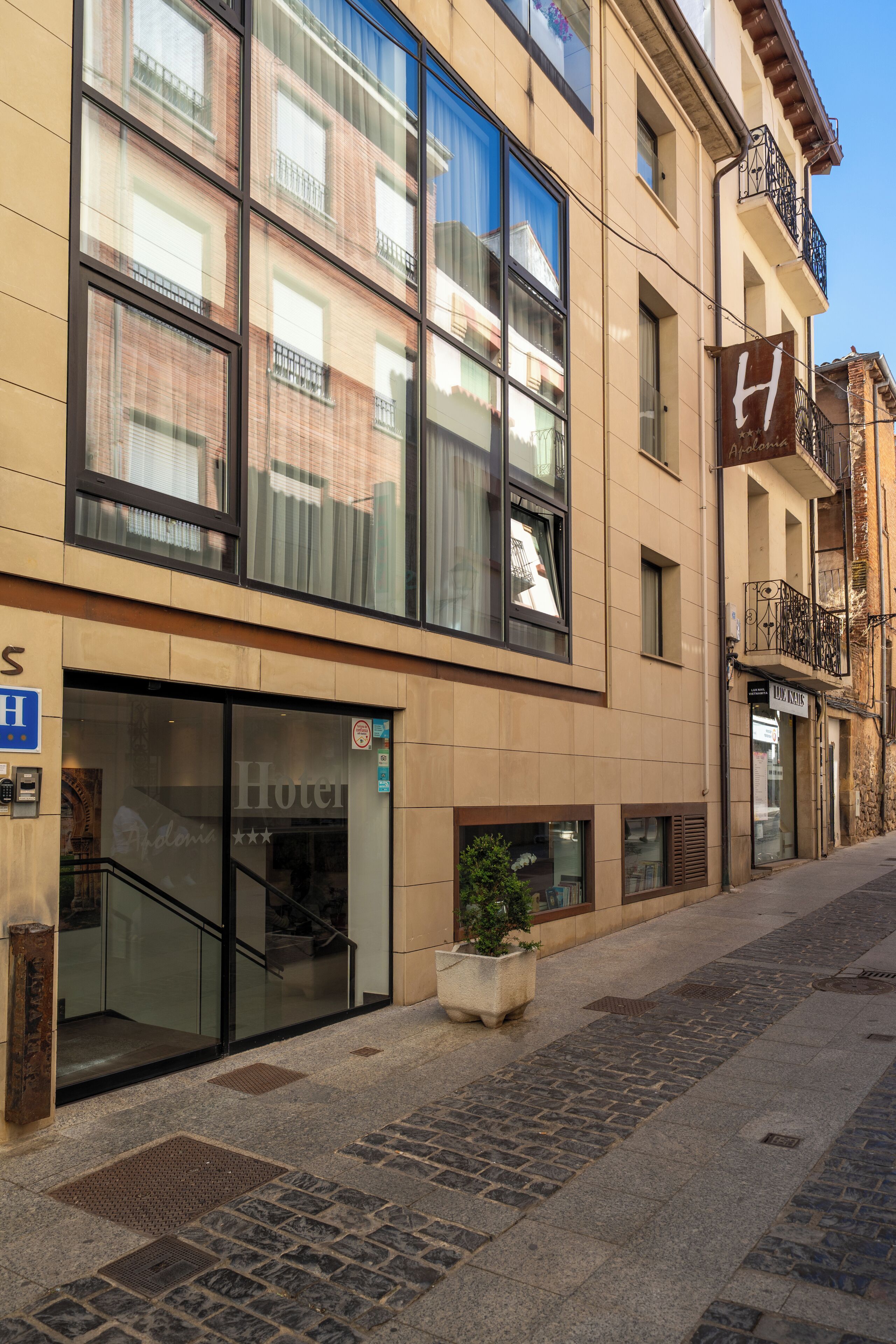 Hotel com fachada moderna, janelas amplas e entrada visível.