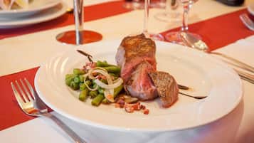 Um prato com bife, vagem e cebola.