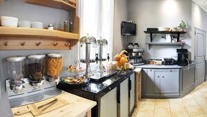 Uma cozinha moderna com espaço para café, uma cesta de frutas e um balcão de refeições.