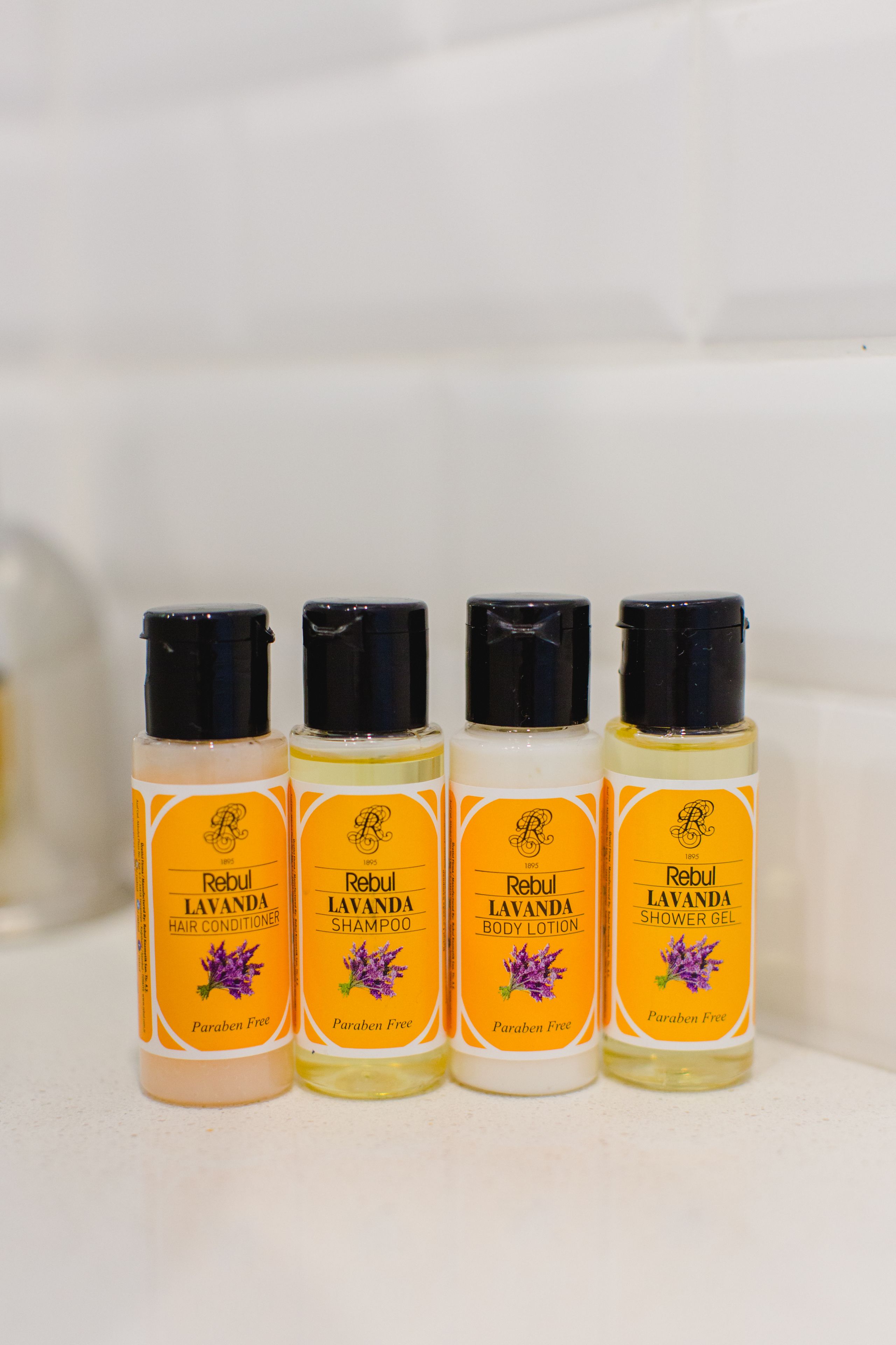 Quatro frascos de condicionador de cabelo, shampoo, loção corporal e gel de banho lavanda Rebul.