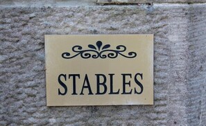 Um letreiro com a palavra 'STABLES' em fundo bege, com detalhes decorativos.