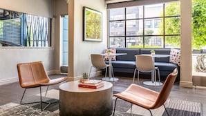 Uma sala de estar moderna com um sofá, duas poltronas e uma mesa de centro.
