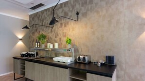 Uma cozinha moderna com bancada de madeira, torradeira embutida e luminária pendente.