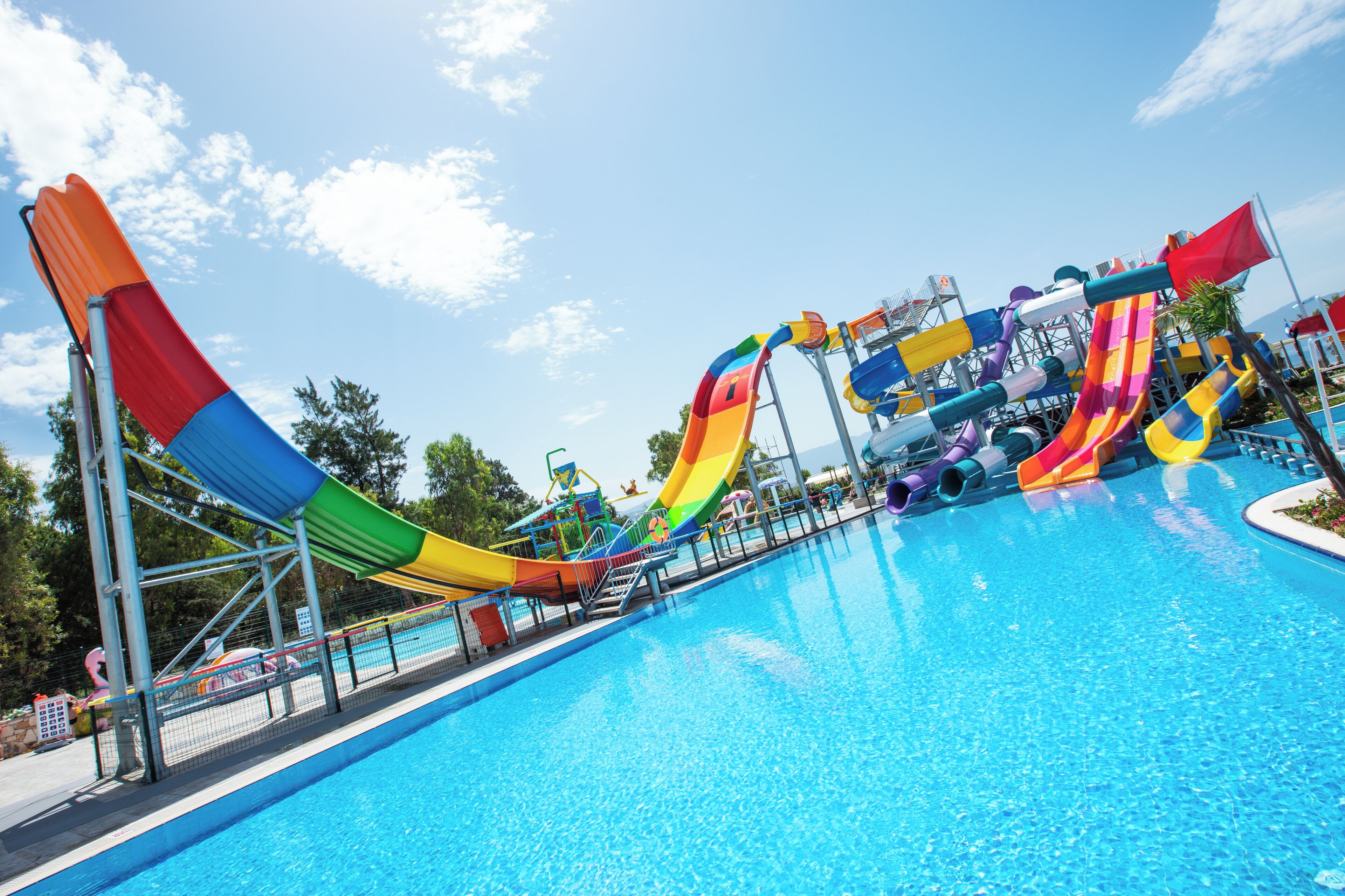 Piscina com vários toboáguas coloridos e céu azul límpido.