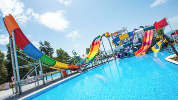 Piscina com vários toboáguas coloridos e céu azul límpido.