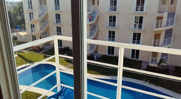 Vista de um edifício residencial com várias varandas e uma piscina.