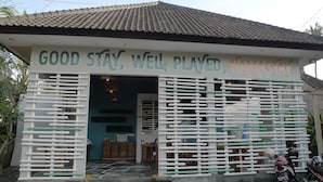 Um edifício com uma placa que diz 'GOOD STAY, WELL PLAYED, NAMASTAY'.
