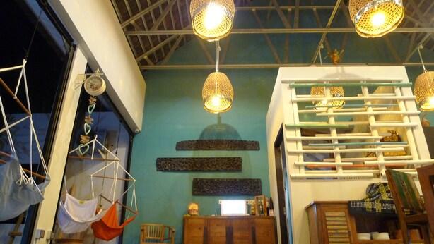 Um quarto com luminárias pendentes, um armário de madeira e uma cadeira.