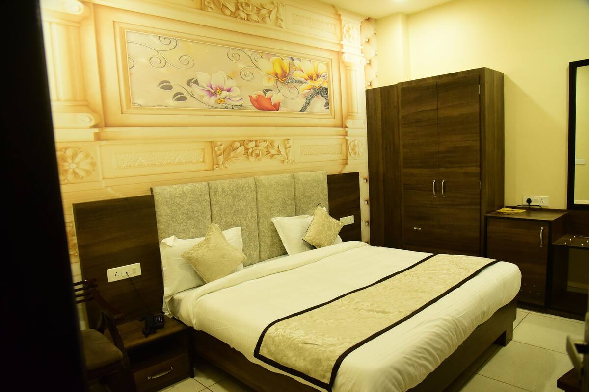 Quarto bem iluminado com uma cama grande, um guarda-roupa e uma mesa de cabeceira.