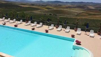 Piscina exterior sazonal, uma piscina transbordante, guarda-sóis