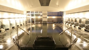 Casa de banho pública com várias pias e uma piscina central.