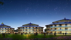 Hotel com várias estruturas abobadadas, um pátio central e um céu noturno estrelado.