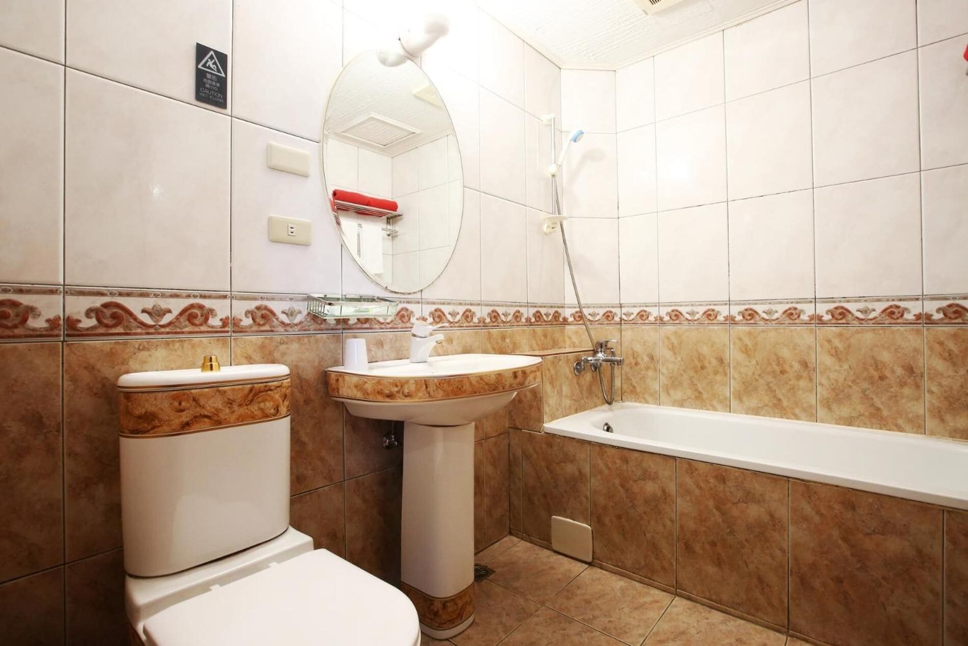 Casa de banho com sanita, lavatório e banheira.