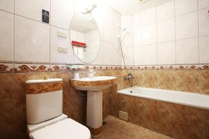 Casa de banho com sanita, lavatório e banheira.