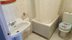 Casa de banho com lavatório, banheira e sanita.