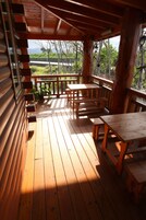 Um deck de madeira com mesas e bancos, com vista para uma paisagem deslumbrante.