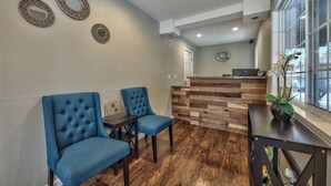 Uma cozinha moderna com detalhes em madeira, uma área de refeições com cadeiras estofadas em azul e espelhos decorativos na parede.