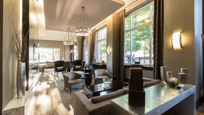 Ampla sala de estar com design moderno, apresentando um sofá, uma mesa de centro e um vaso decorativo.