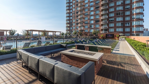 Uma área de piscina no terraço com espreguiçadeiras e uma lareira.