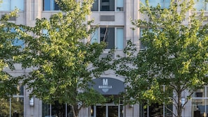 Um hotel de vários andares com fachada de tijolos, janelas grandes e uma placa com a inscrição 'MARBELLA'.