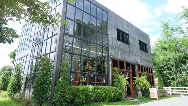 Um edifício moderno com grandes janelas de vidro e fachada de concreto.