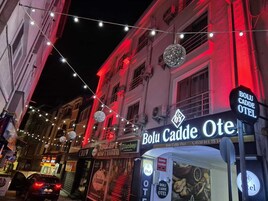 Um hotel chamado "Bolu Cadde Otel" com uma placa indicando "Sulemin Lezzetleri" e um número de contato.