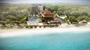 Resort com piscina, praia e um edifício de design tradicional.