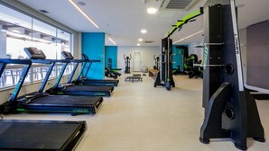 Academia com esteiras, aparelhos de musculação e bolas de exercício.