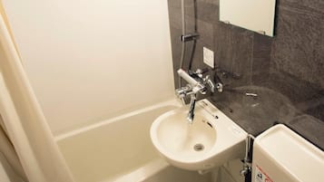 Um banheiro compacto com banheira, pia e vaso sanitário.