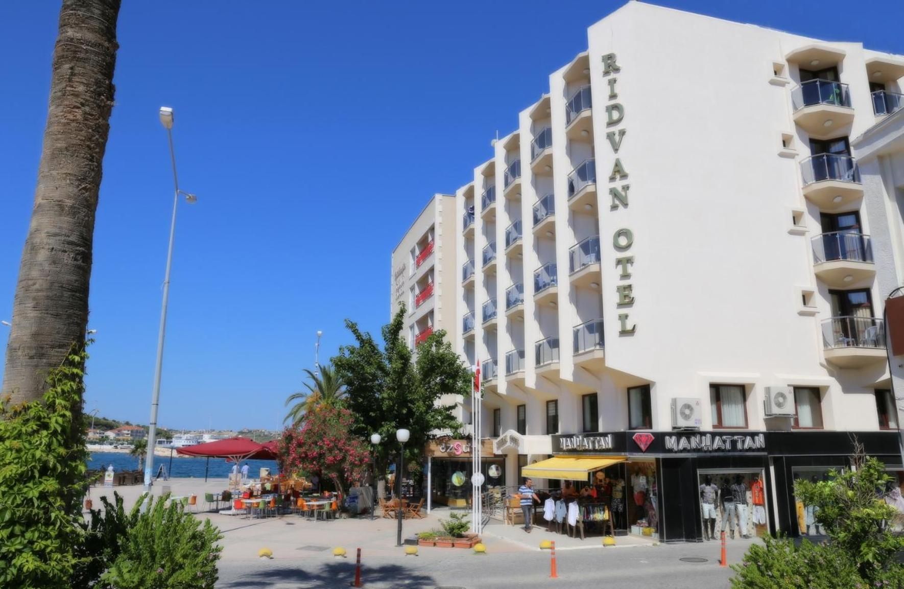 Um hotel com várias varandas, uma loja com manequins e um céu azul límpido.