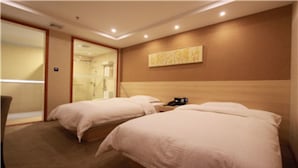 Quarto de hotel com duas camas, chuveiro e um quadro na parede.