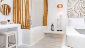 Uma casa de banho moderna com banheira, chuveiro e toucador com espelho.