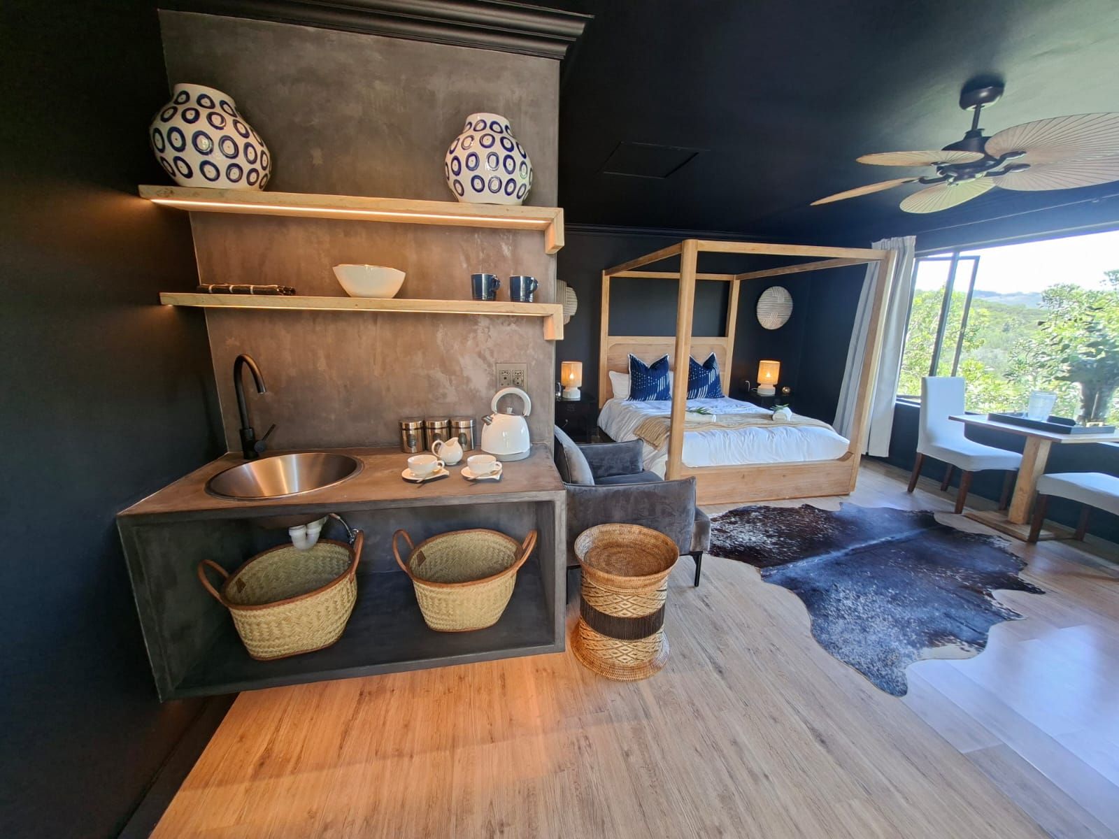 Quarto moderno com uma cama grande, cabeceira de madeira, mesas de cabeceira e vista para o exterior.