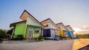 Uma fileira de casas coloridas com telhados inclinados e um caminho de acesso pavimentado.