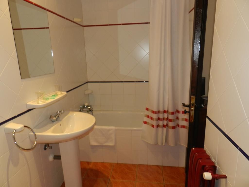 Uma casa de banho com lavatório, espelho e banheira.
